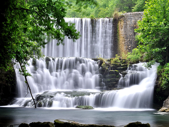 Nature's perfect curtain call &ndash; Mirror Lake Waterfall cascades in tiers of white froth, framed by vibrant green foliage that seems to applaud its performance.