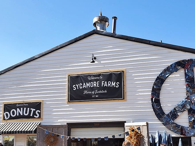 The iconic white barn at Sycamore Farms welcomes treasure hunters with promises of donuts and vintage delights beneath that charming peace sign.