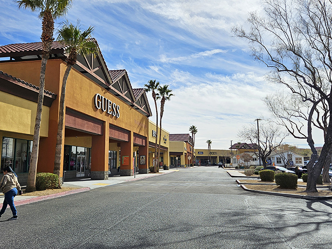Spanish-style architecture meets desert bargain hunting. Palm trees stand guard over the Guess storefront like sentinels of savings.