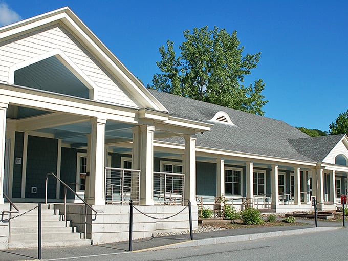 The stately exterior of LISTEN Thrift Store stands like a New England mansion of bargains, promising treasures behind its welcoming columns.