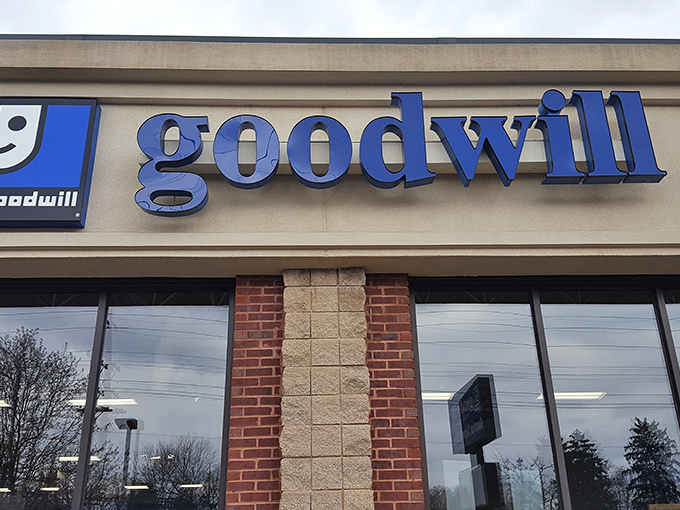 The iconic blue Goodwill sign beckons bargain hunters like a retail lighthouse, promising treasures within this Louisville thrifting institution.