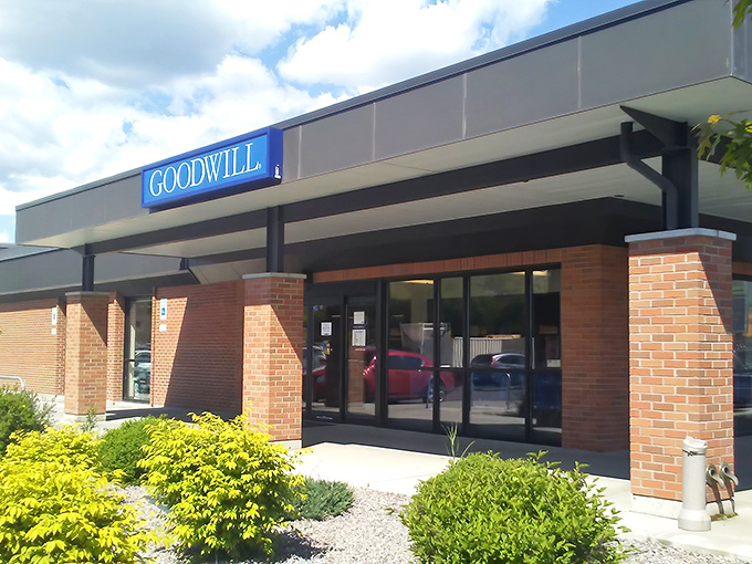 The iconic blue Goodwill sign beckons like a thrift siren, promising treasures within those brick walls that would make any bargain hunter's heart race.