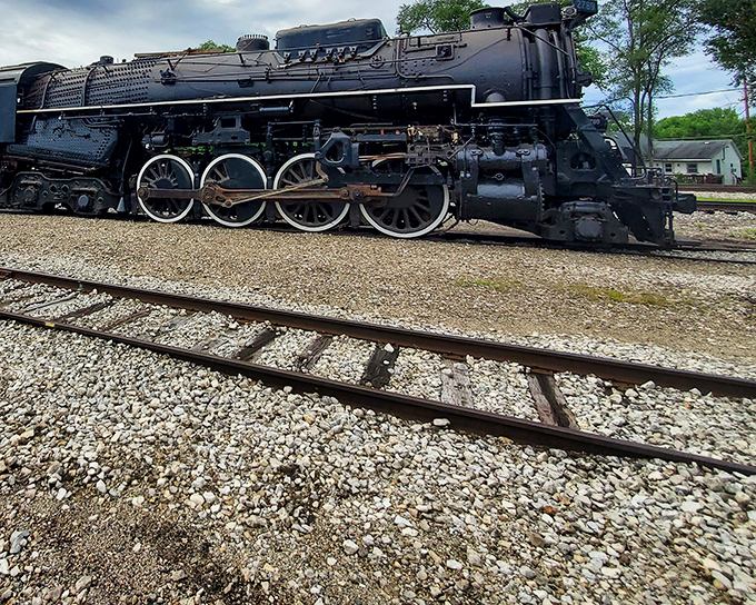 This magnificent steam locomotive stands like a sleeping giant, its massive drive wheels and gleaming black frame a testament to American engineering prowess that once thundered across the Midwest.