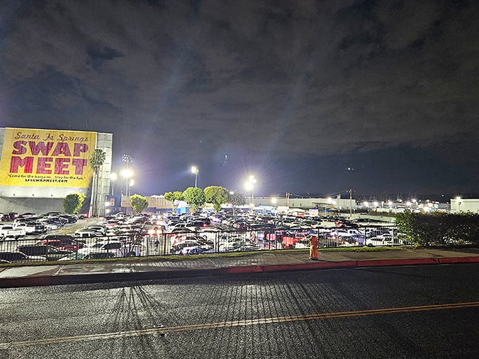 The iconic yellow sign beckons bargain hunters like a retail lighthouse, with a sea of cars filling the lot under the night sky.