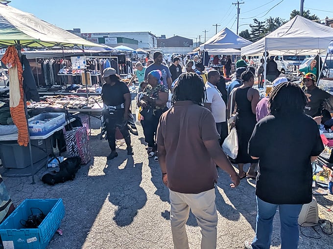 The bustling aisles of Quaker City Flea Market, where treasure hunters navigate a sea of possibilities under white tents and blue skies.