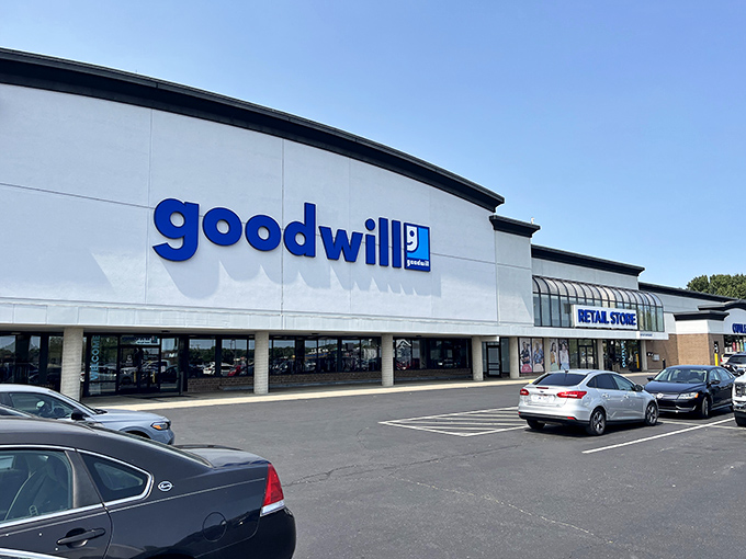 The blue Goodwill sign beckons like a lighthouse for bargain hunters, promising treasures within this unassuming Columbus strip mall location.