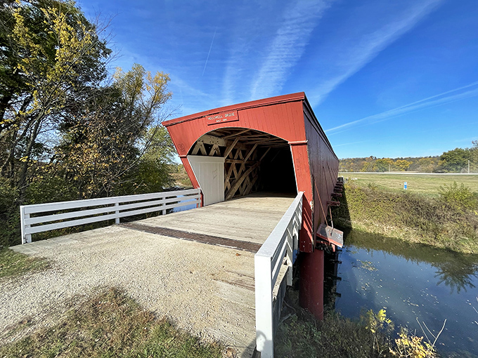 The crimson facade of Holliwell Bridge welcomes visitors like an old friend, standing proudly against Iowa's impossibly blue summer sky.