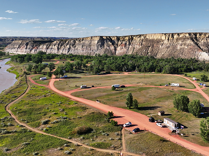 Dramatic badlands cliffs stand sentinel over a peaceful campground where RVs dot the landscape like modern-day covered wagons. Nature's skyscrapers without the traffic.