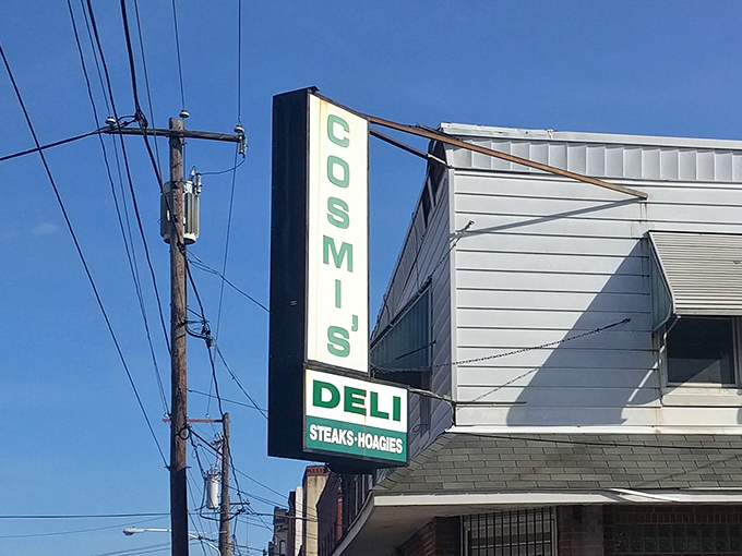 The iconic green sign beckons like a lighthouse for sandwich lovers. Cosmi's vertical marquee has guided hungry Philadelphians to hoagie heaven for generations.