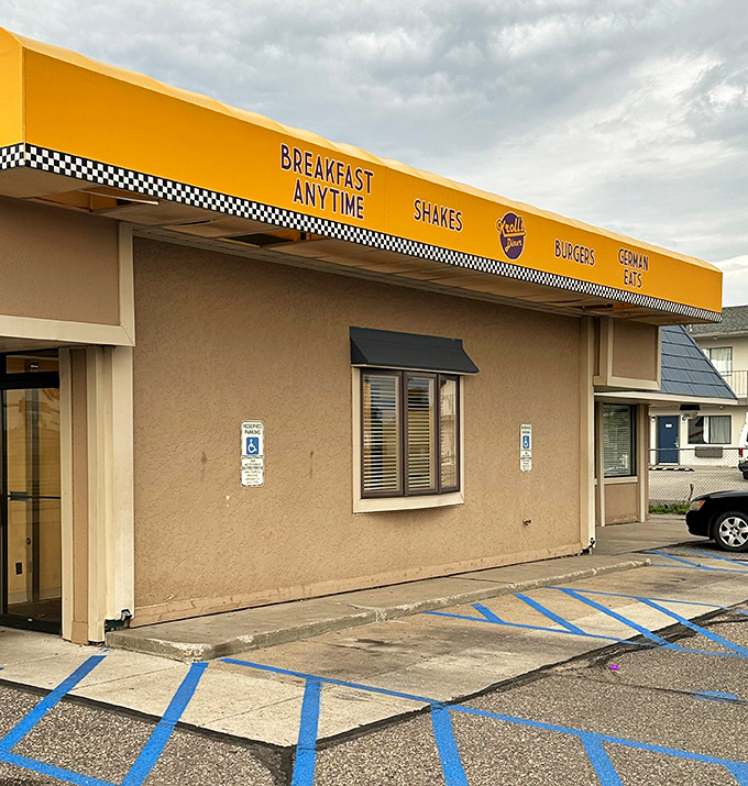 The golden awning of Kroll's Diner beckons like a breakfast lighthouse, promising "Breakfast Anytime" to hungry North Dakotans seeking comfort food salvation.