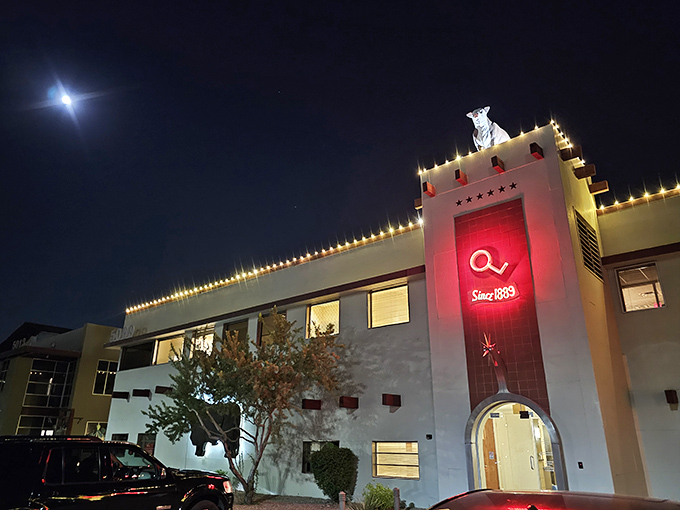 The iconic steer silhouette stands guard atop The Stockyards, illuminated against the night sky like a beacon for hungry carnivores.