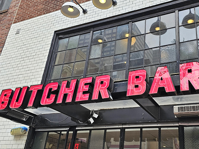 The neon-red "BUTCHER BAR" sign glows like a carnivore's North Star against white subway tile, beckoning meat lovers from across Philadelphia.
