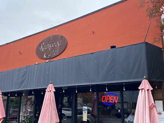 The terracotta-colored exterior of Redwood Cafe stands out like a cheerful beacon, promising comfort food treasures within its unassuming walls.