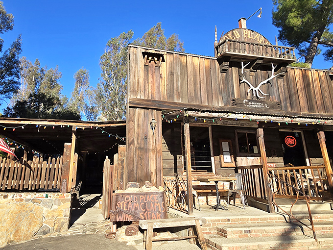 The Old Place stands proudly against the California sky, its weathered wooden facade and antler decoration announcing: "Yes, time travel is possible."