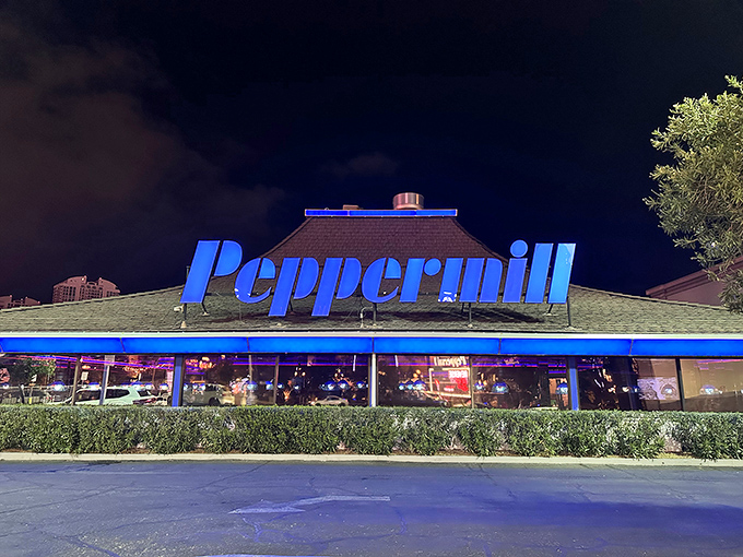 The Peppermill sign glows against the night sky, promising a cocktail and a classic, comforting meal inside.