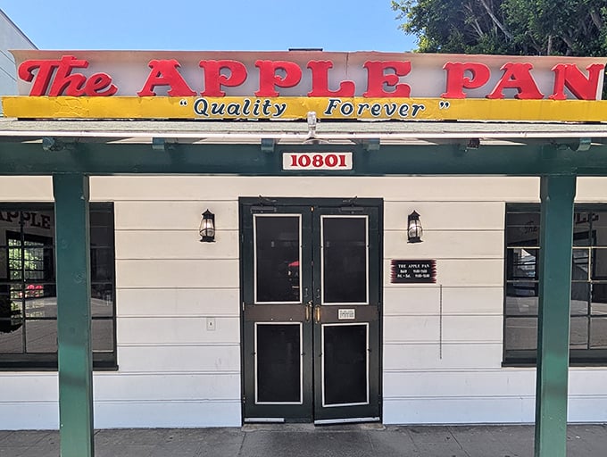The unassuming white exterior of The Apple Pan stands like a time capsule on Pico Boulevard, its vintage sign promising "Quality Forever."