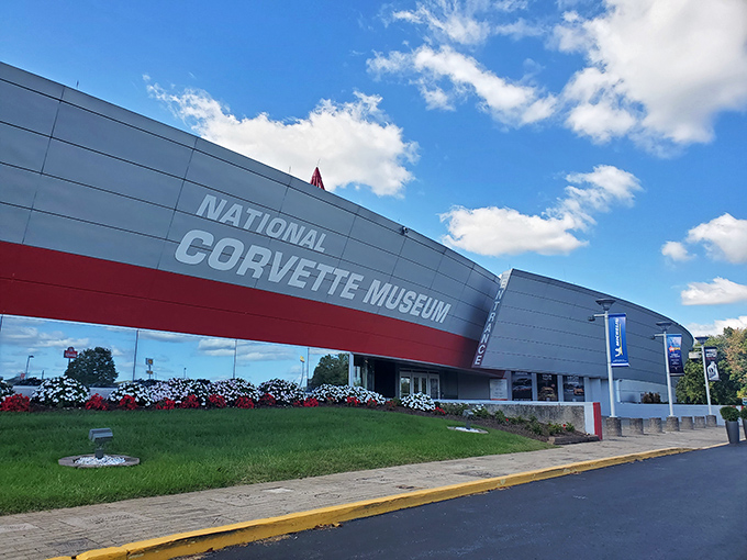 The sleek, modern exterior of the National Corvette Museum stands like a spaceship that landed in Kentucky, complete with its signature red spire reaching skyward.
