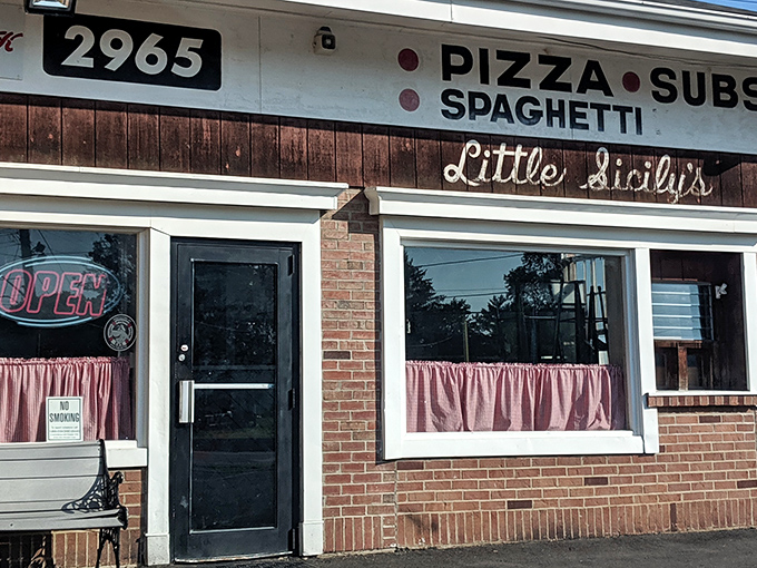 The unassuming brick facade of Little Sicily's hides culinary treasures within. Like finding a Picasso at a yard sale, this modest exterior belies the pizza masterpieces inside.