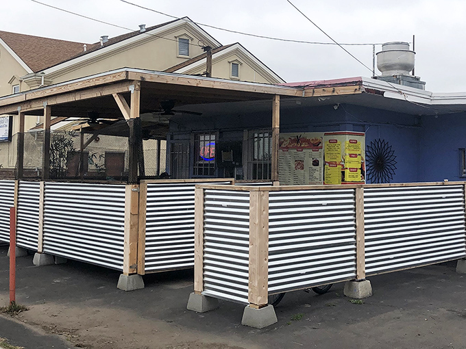 A humble covered patio with corrugated metal fencing creates that perfect "you've discovered something special" atmosphere that makes neighborhood gems so satisfying.