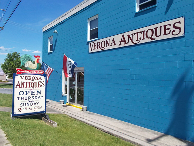 The turquoise beacon of Verona Antiques stands out like a peacock at a pigeon convention, complete with that charming rooster sign inviting treasure hunters Thursday through Sunday.