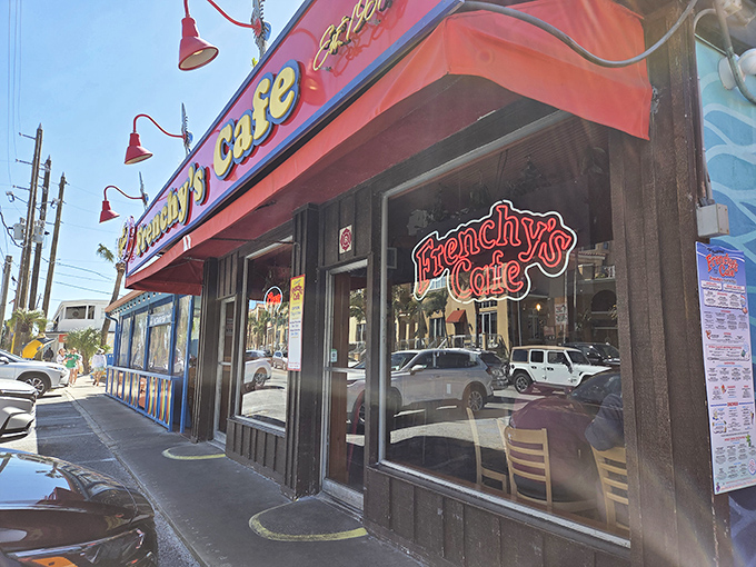 The unassuming exterior of Frenchy's Original Cafe with its iconic red awning and neon signage beckons seafood lovers to Clearwater Beach.