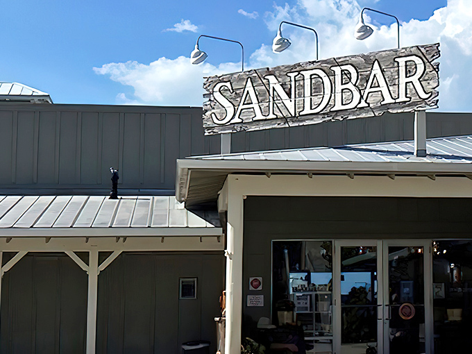 Blue skies frame Sandbar's rustic signage like nature's own Instagram filter, promising the kind of coastal dining experience that vacation memories are made of.