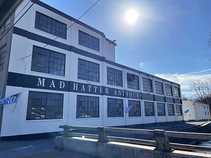 The imposing white facade of Mad Hatter Antiques stands like a time portal in Adamstown, promising treasures within its industrial-chic walls.