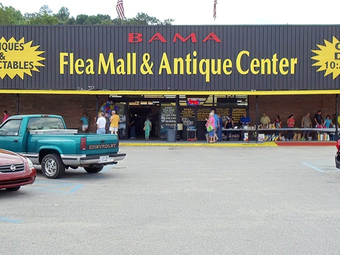 The iconic black and yellow storefront of Bama Flea Mall beckons treasure hunters like a siren call to bargain paradise.