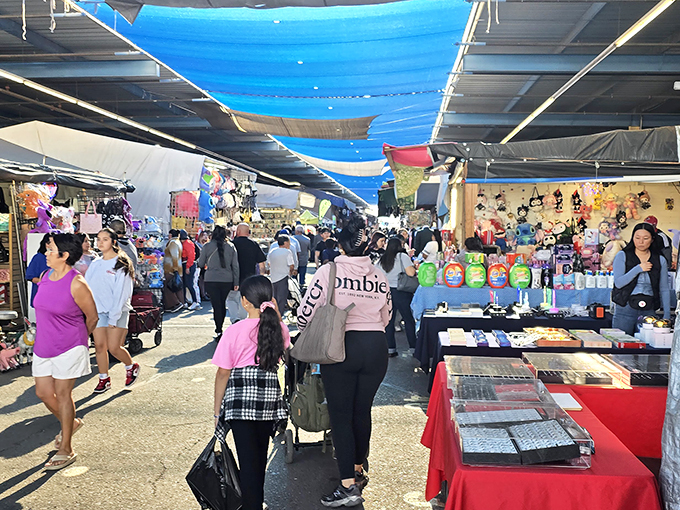 Blue tarps create a desert oasis of commerce where shoppers hunt for treasures while vendors call out deals like carnival barkers with better merchandise.
