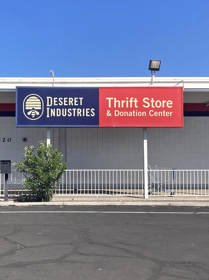 The blue and red sign beckons like a lighthouse for bargain hunters. Welcome to Deseret Industries, where thrifting dreams come true in Mesa's desert landscape.