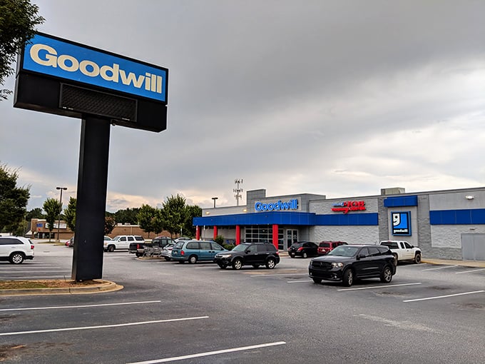 The iconic blue Goodwill sign beckons like a lighthouse for bargain hunters navigating the sea of retail on Woodruff Road.