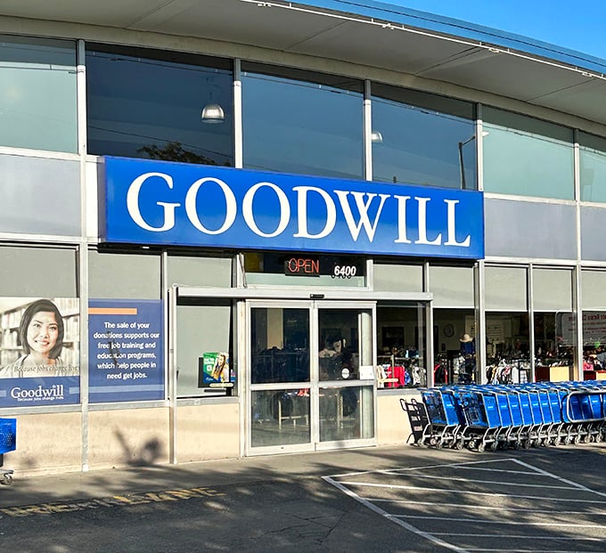 The iconic blue Goodwill sign beckons bargain hunters like a retail lighthouse. Seattle's notorious drizzle can't dampen the thrill of what treasures await inside.