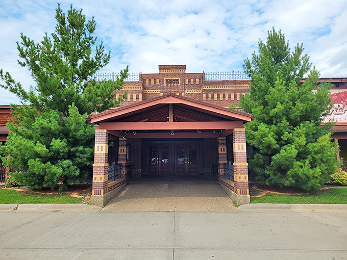 The grand entrance to Hickory Park welcomes hungry pilgrims with rustic charm and evergreen sentinels standing guard. BBQ paradise awaits!