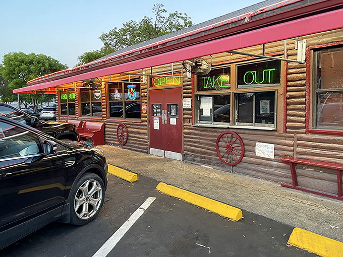 The rustic log cabin exterior of Shiver's BBQ beckons with neon promise – where wagon wheels meet world-class barbecue in an unpretentious Florida landmark.