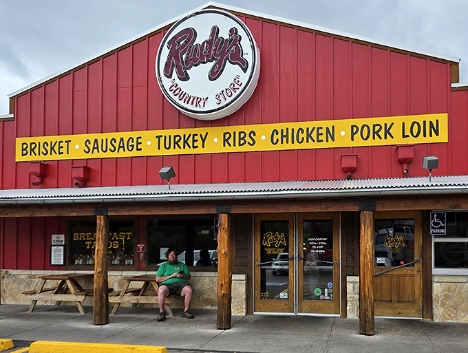 The bright red building with its yellow menu banner stands like a barbecue lighthouse, guiding hungry souls to smoky salvation in Colorado Springs.