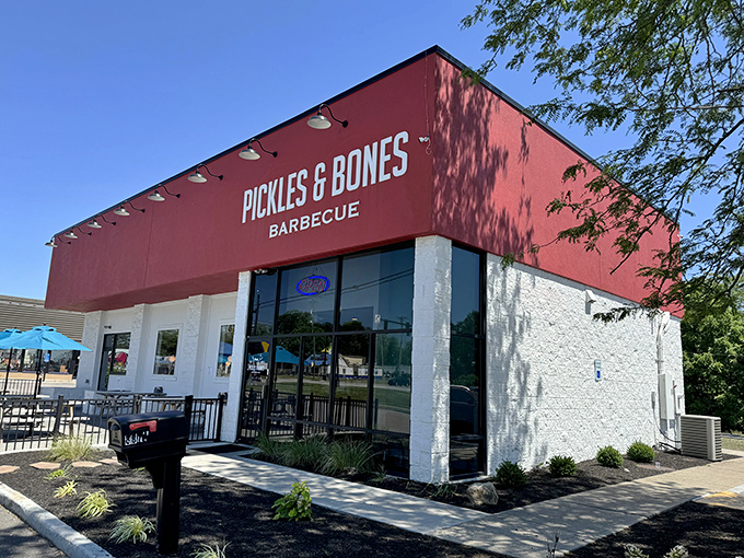 Sunshine highlights the bold red facade of this BBQ sanctuary, where meat pilgrims gather to worship at the altar of smoke and patience.