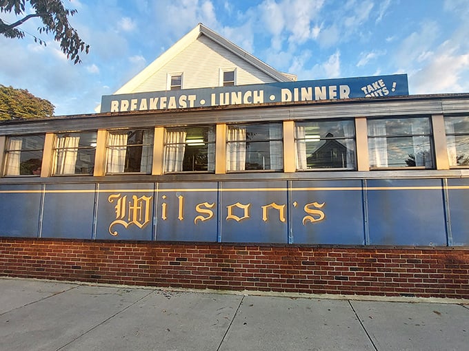 The blue-and-gold façade of Wilson's Diner stands like a time capsule on Waltham's Main Street, promising comfort food salvation to hungry Massachusetts souls.
