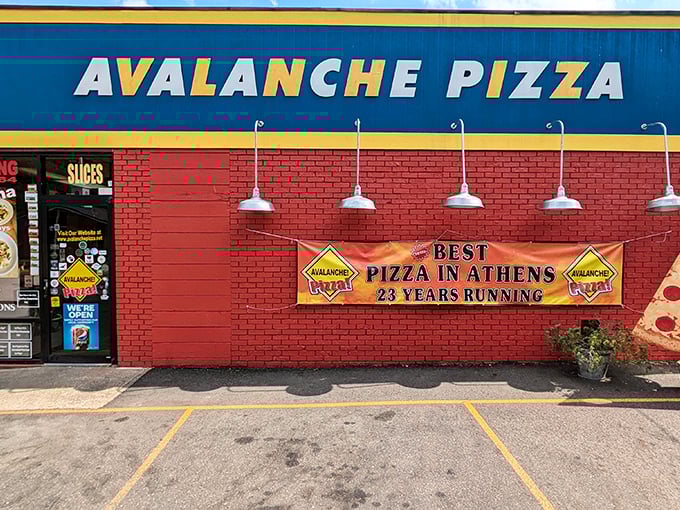 The vibrant red brick and bold blue signage of Avalanche Pizza stands as a beacon of culinary promise on East State Street in Athens.