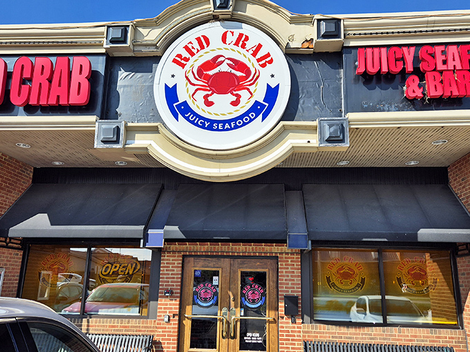 The iconic Red Crab storefront beckons seafood lovers with its bold signage and promise of "Juicy Seafood" &ndash; a coastal oasis in Cleveland's urban landscape.