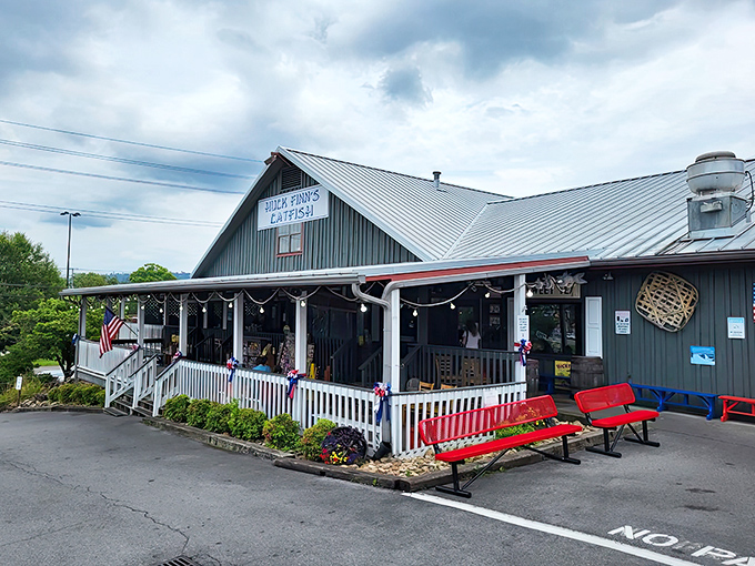 The rustic exterior of Huck Finn's Catfish welcomes hungry visitors with its metal roof and inviting covered porch in Pigeon Forge.