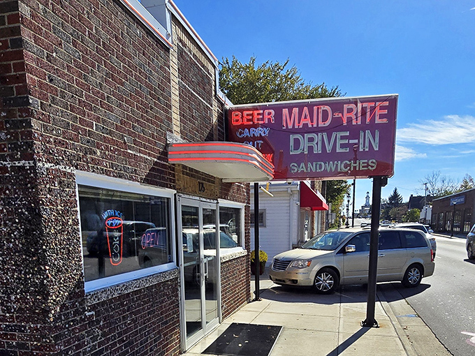 The neon glow of Maid-Rite's sign has been beckoning hungry travelers since 1934, a brick-and-mortar time machine serving comfort on a bun. 