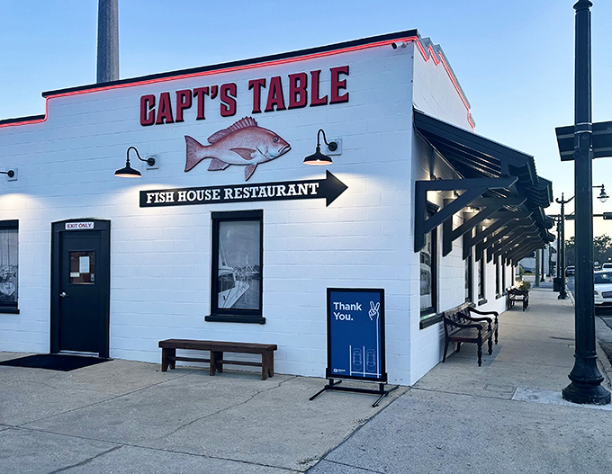 The iconic white exterior of Captain's Table glows at dusk, with its bold red signage promising seafood treasures within. A perfect coastal beacon for hungry travelers.