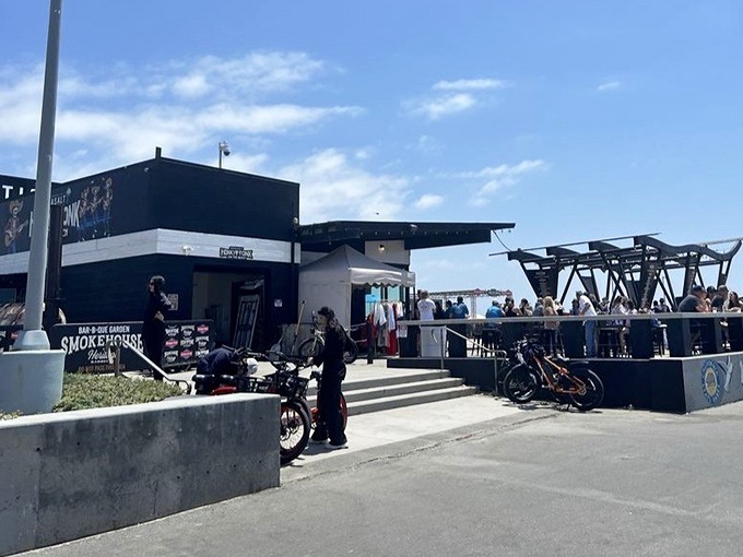 Surf's up at Sea Salt's daytime setup, where the black building stands as a beacon for hungry beachgoers seeking refuge from ordinary boardwalk fare.