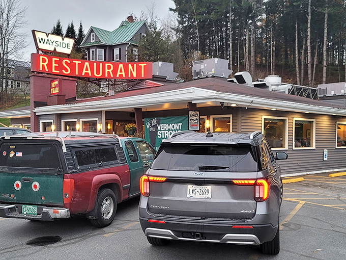 That iconic red neon sign beckons like an old friend, promising comfort food salvation after a long Vermont day. No pretension, just honest cooking awaits.