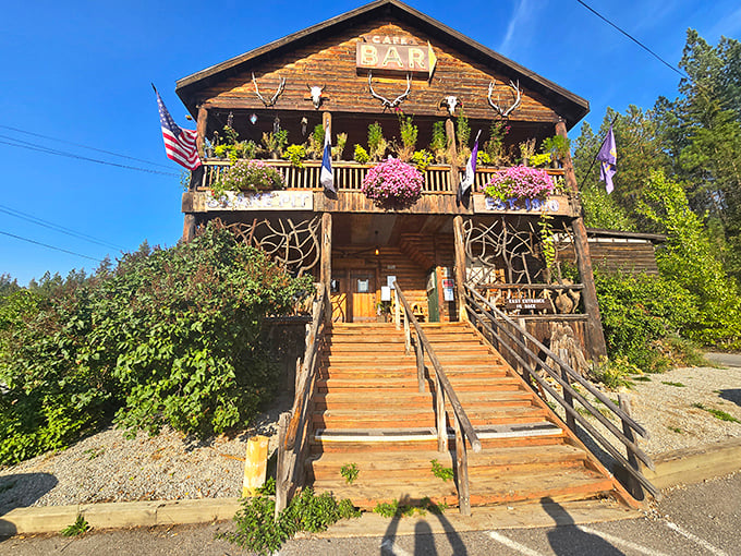 Summer brings vibrant hanging baskets to The Snake Pit's wooden porch, where American flags flutter in the mountain breeze—Idaho hospitality at its finest.