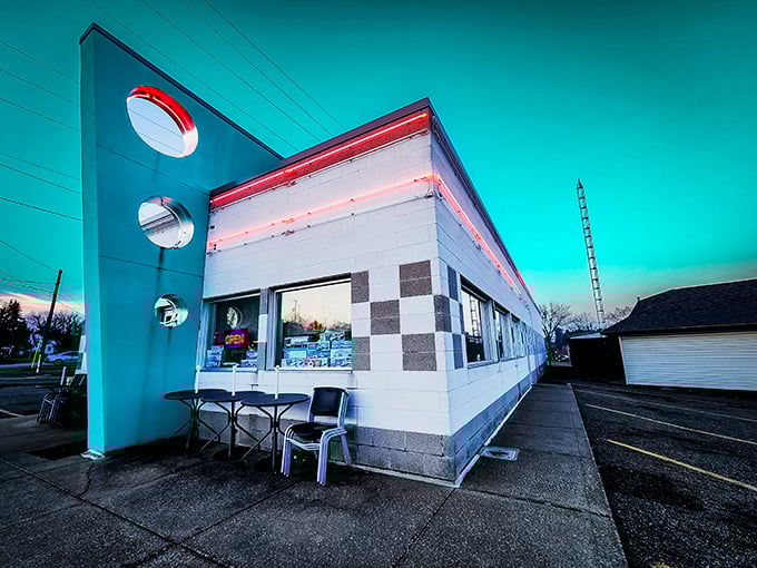 The turquoise fin and circular windows of Doug's Classic '57 Diner glow against the twilight sky, a beacon of mid-century charm calling hungry travelers home.