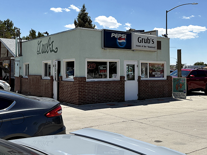 The unassuming mint-green exterior of Grub's Drive-In stands as a time capsule of Americana, promising burger perfection behind that humble facade.