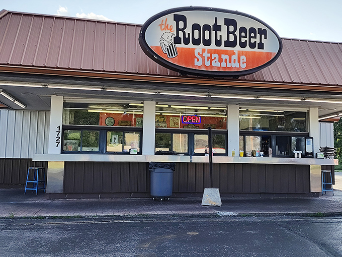 The humble exterior of The Root Beer Stande stands as a time capsule of Americana, where culinary treasures await behind those unassuming service windows.