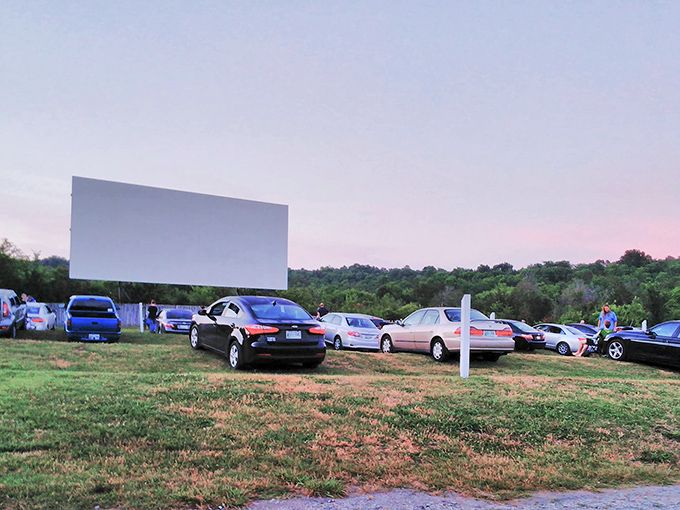 Twilight magic unfolds as cars gather before the giant screen, where modern vehicles become time machines transporting families back to simpler days.