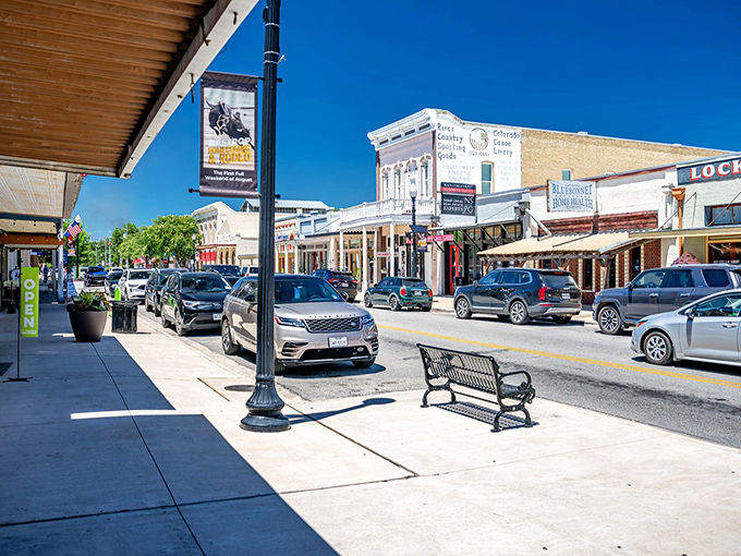Another angle of Main Street reveals the small-town charm that makes Bastrop special - complete with vintage lampposts and benches perfect for people-watching without premium pricing.